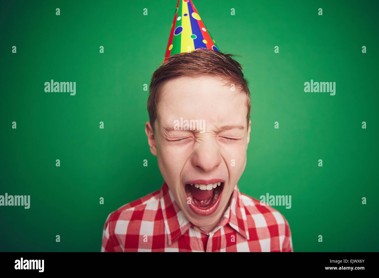 Cute boy in birthday cap screaming Stock Photo - Alamy