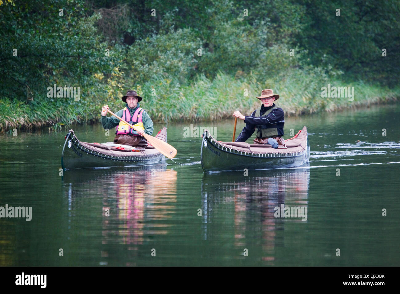 Two men paddling in canoes Stock Photo - Alamy