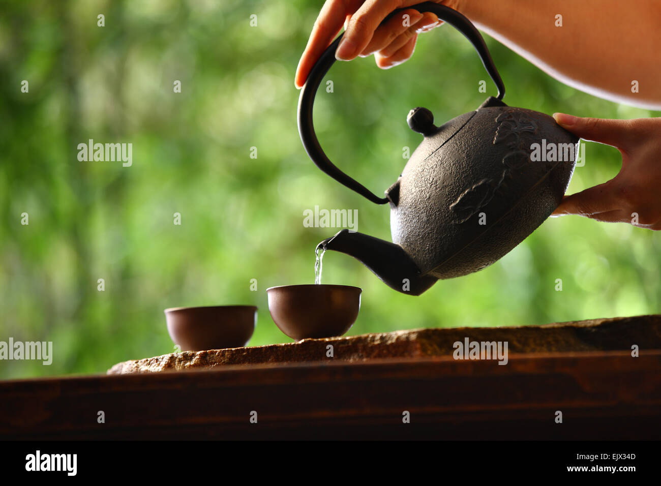 One hand holding the teapot in tea Stock Photo - Alamy