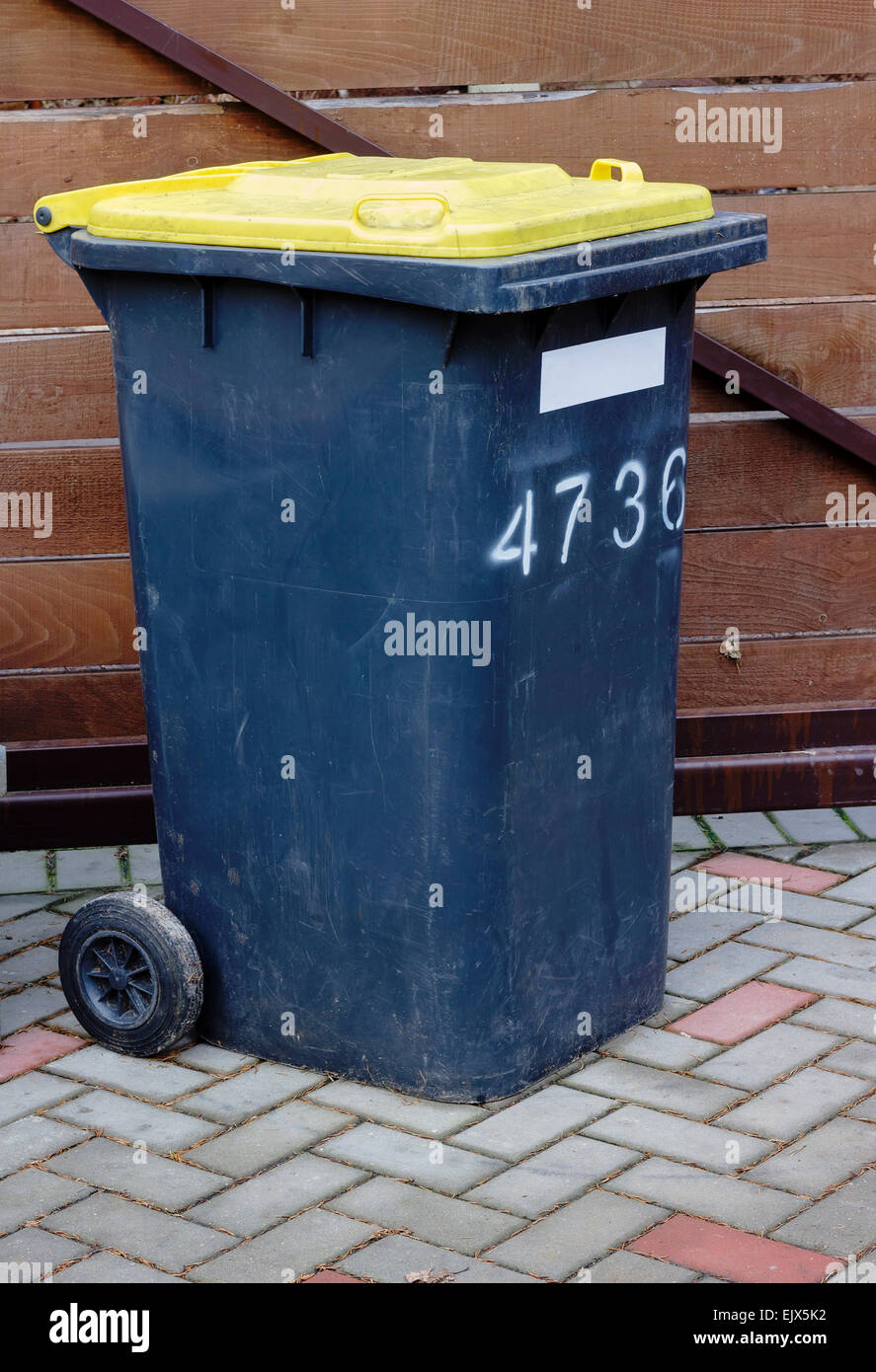 The real old dirty plastic garbage container with a yellow cover Stock ...