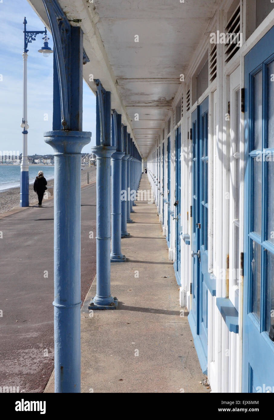 Deserted seaside promenade - solitary woman walking away - parallel ...