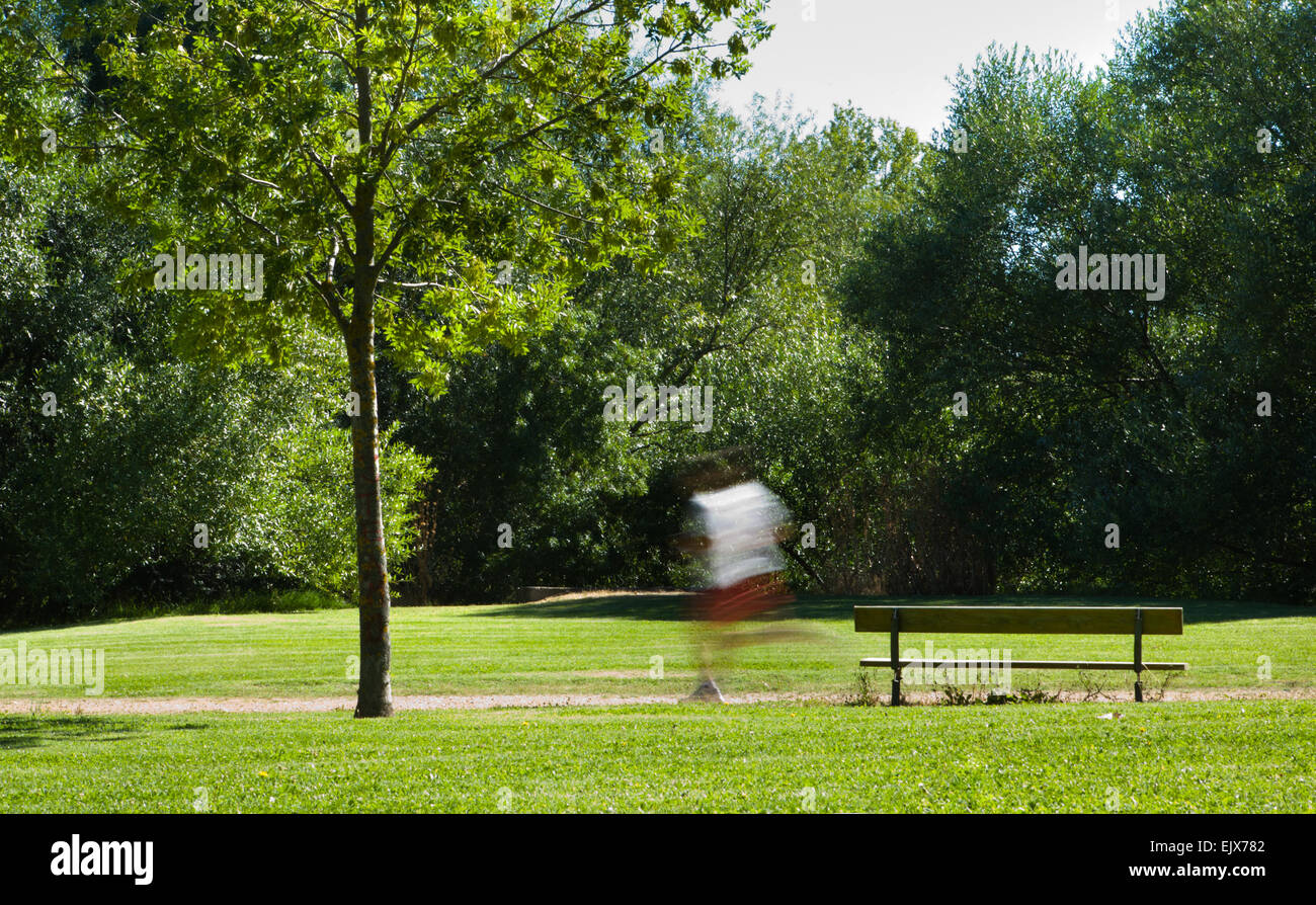 Man running alone in the park getting closer to bench Stock Photo - Alamy