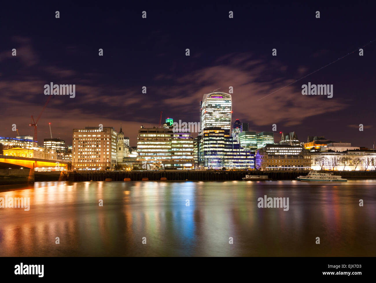 Night shot of the illuminated City of London riverside from the River ...