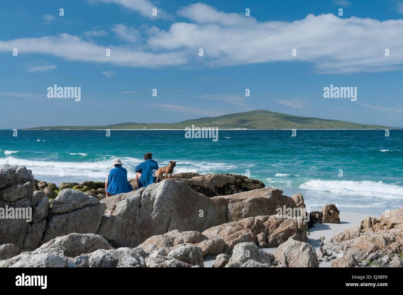 waves crashing at pabbay view with walkers / tourist relaxing with ...