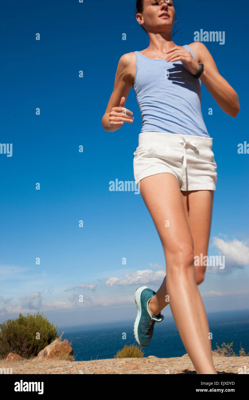 Woman Running along Cliff by Ocean Stock Photo - Alamy