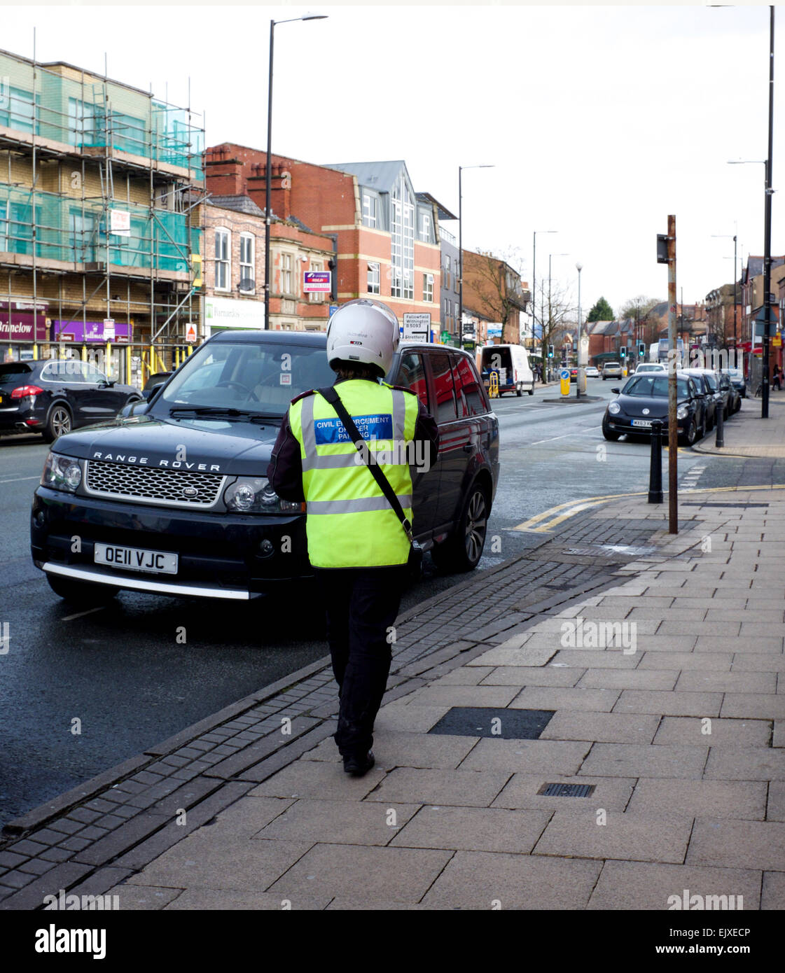 A parking warden walks along Wilmslow Road in Didsbury, south ...