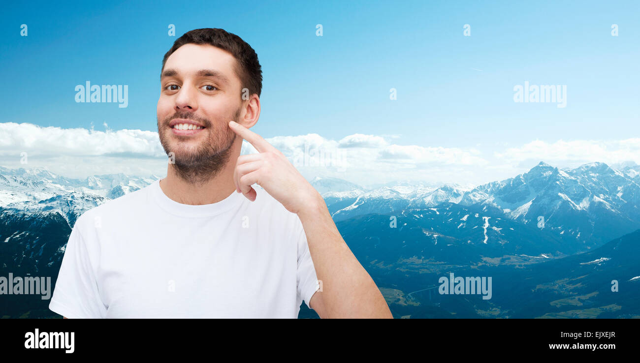 smiling young handsome man pointing to cheek Stock Photo - Alamy