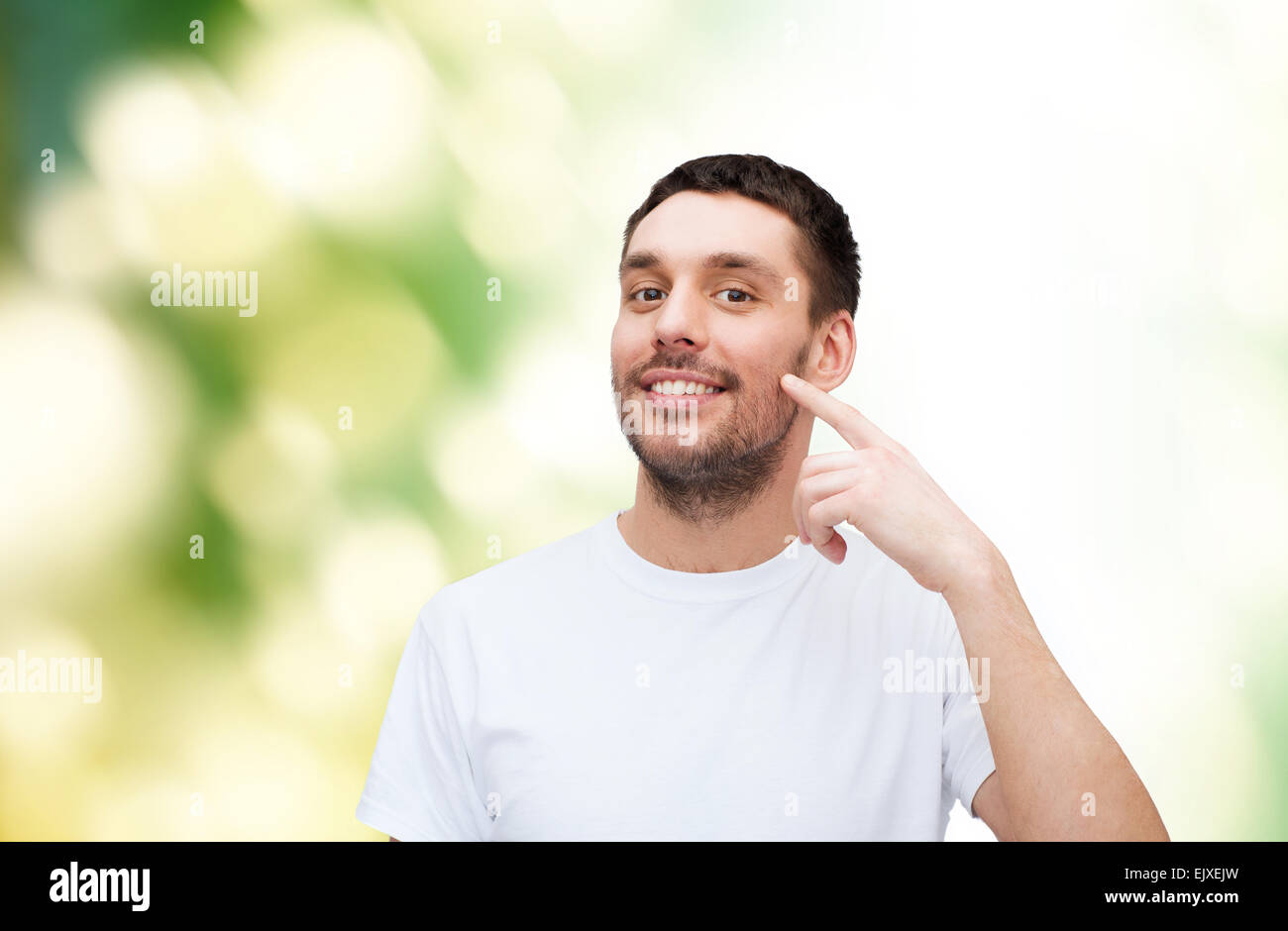 smiling young handsome man pointing to cheek Stock Photo - Alamy
