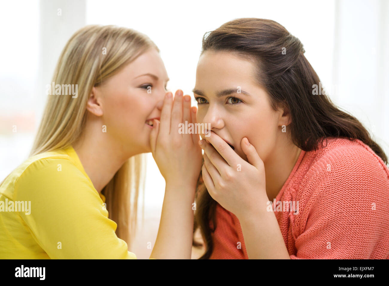 one girl telling another secret Stock Photo - Alamy