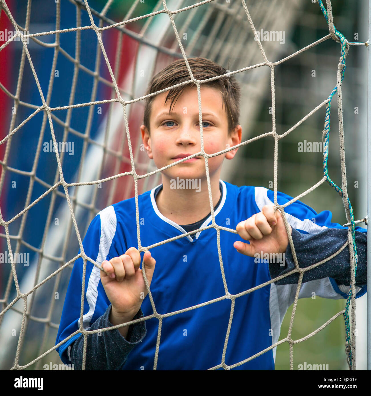 Little boy plays football on stadium Stock Photo - Alamy
