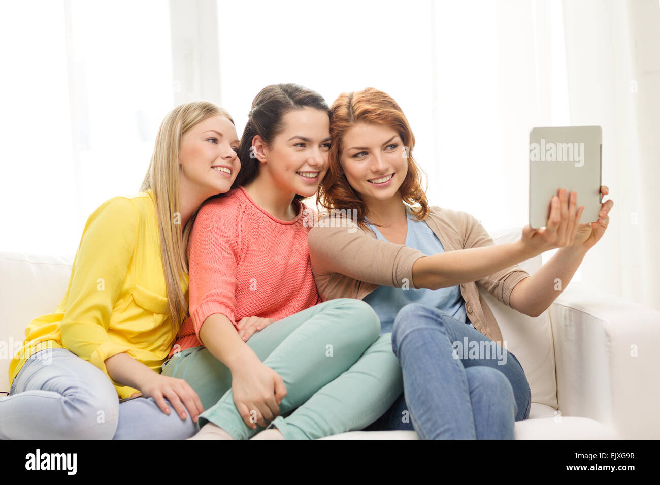 three smiling teenage girls with tablet pc at home Stock Photo - Alamy