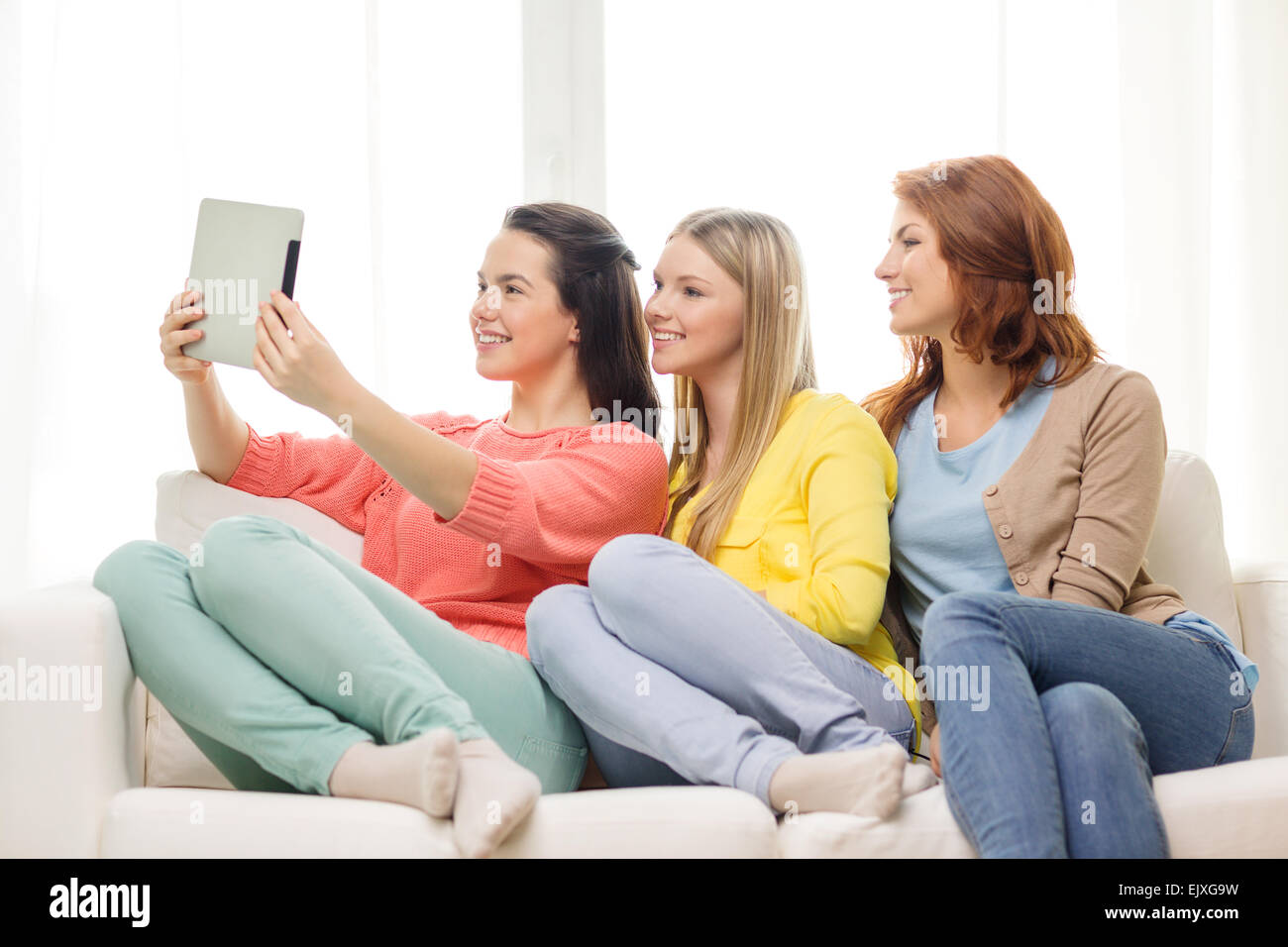 three smiling teenage girls with tablet pc at home Stock Photo - Alamy
