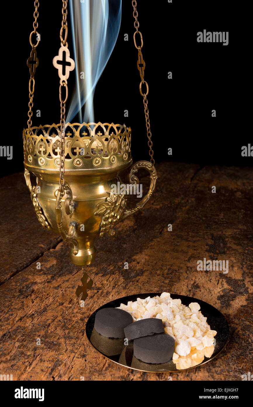 Smoking incense thurible and a golden plate with franincense and ...