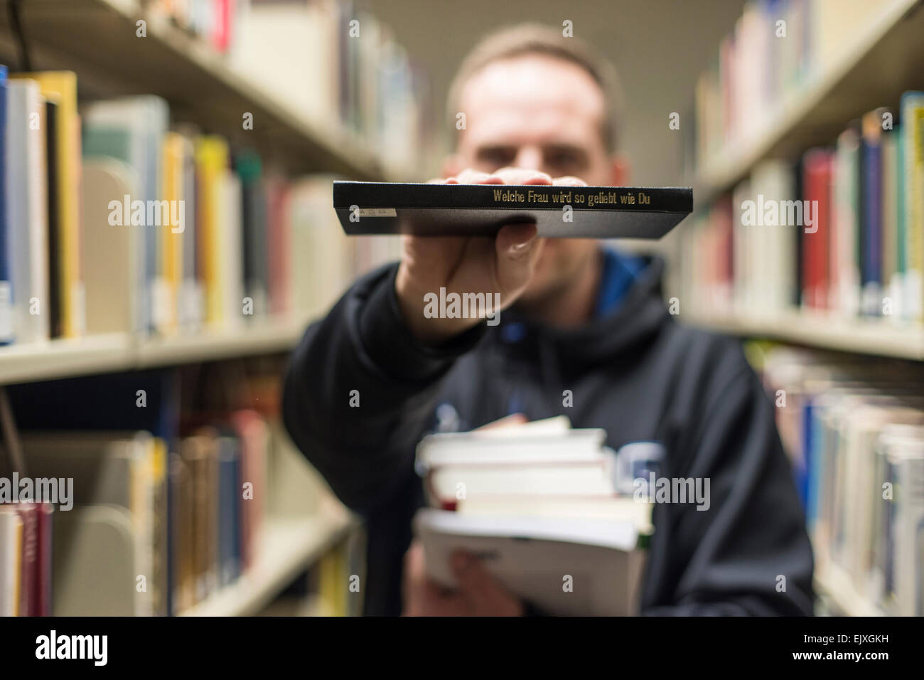 Man showing book in library Stock Photo - Alamy