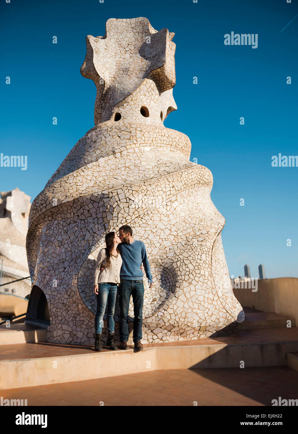 Spain, Barcelona, couple kissing on rooftop of Casa Mila Stock Photo ...