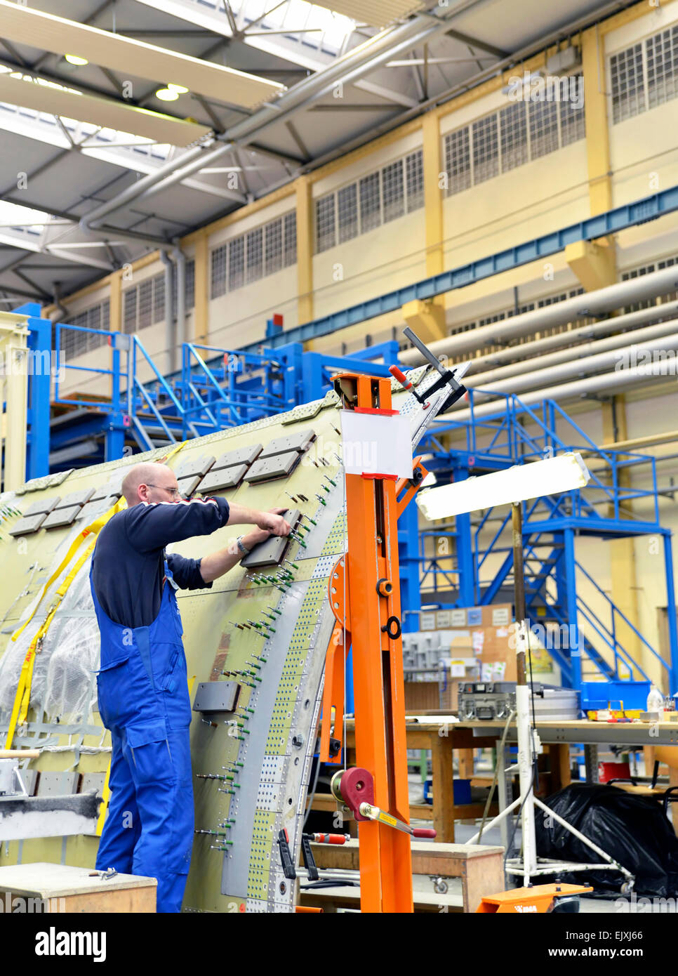 Man working on airplane in a hangar Stock Photo - Alamy