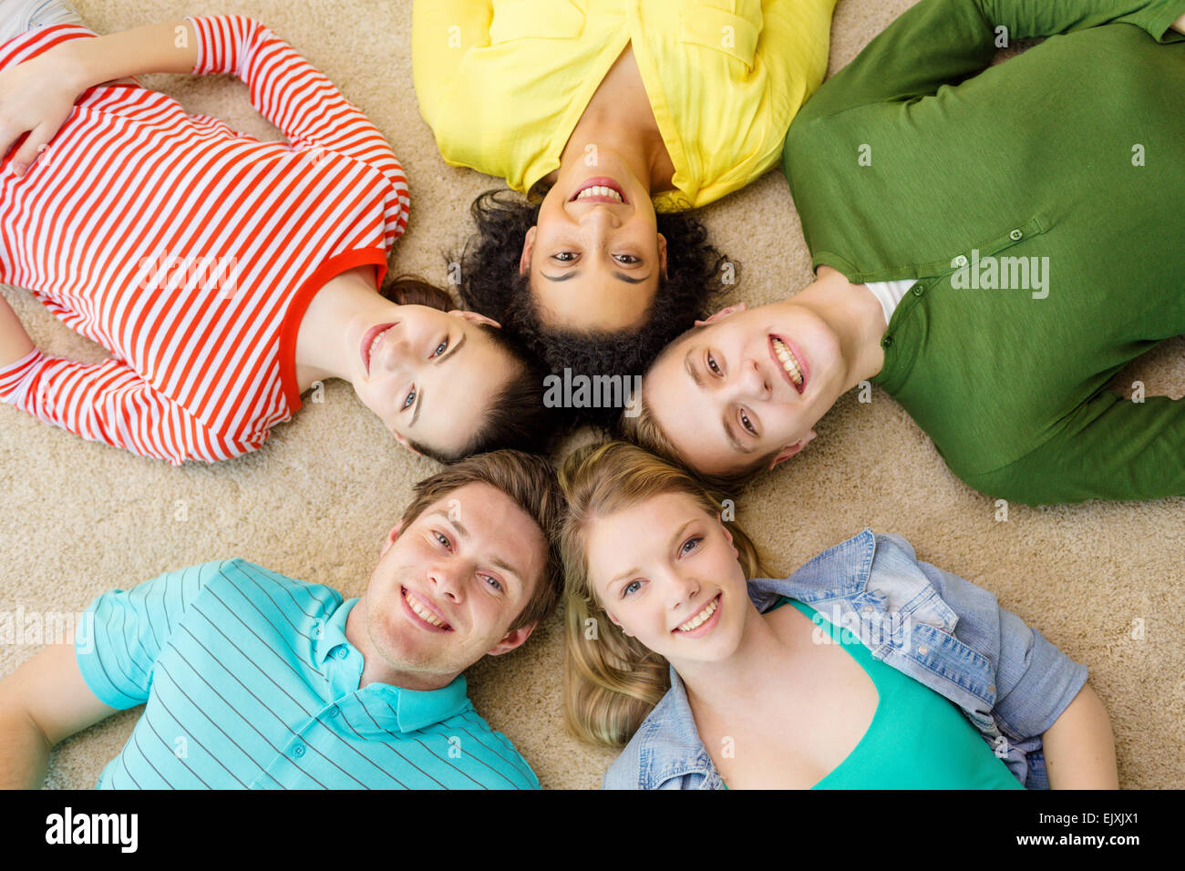 group of smiling people lying down on floor Stock Photo - Alamy