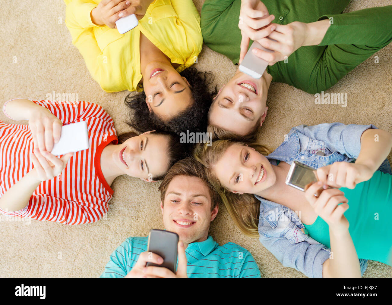 group of smiling people lying down on floor Stock Photo - Alamy