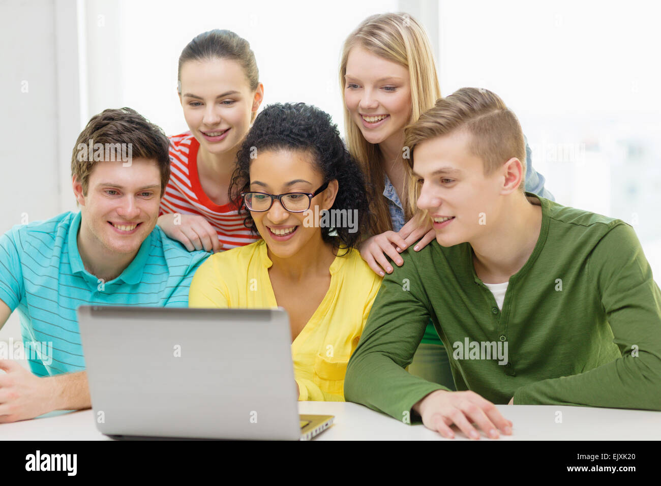 smiling students looking at laptop at school Stock Photo - Alamy