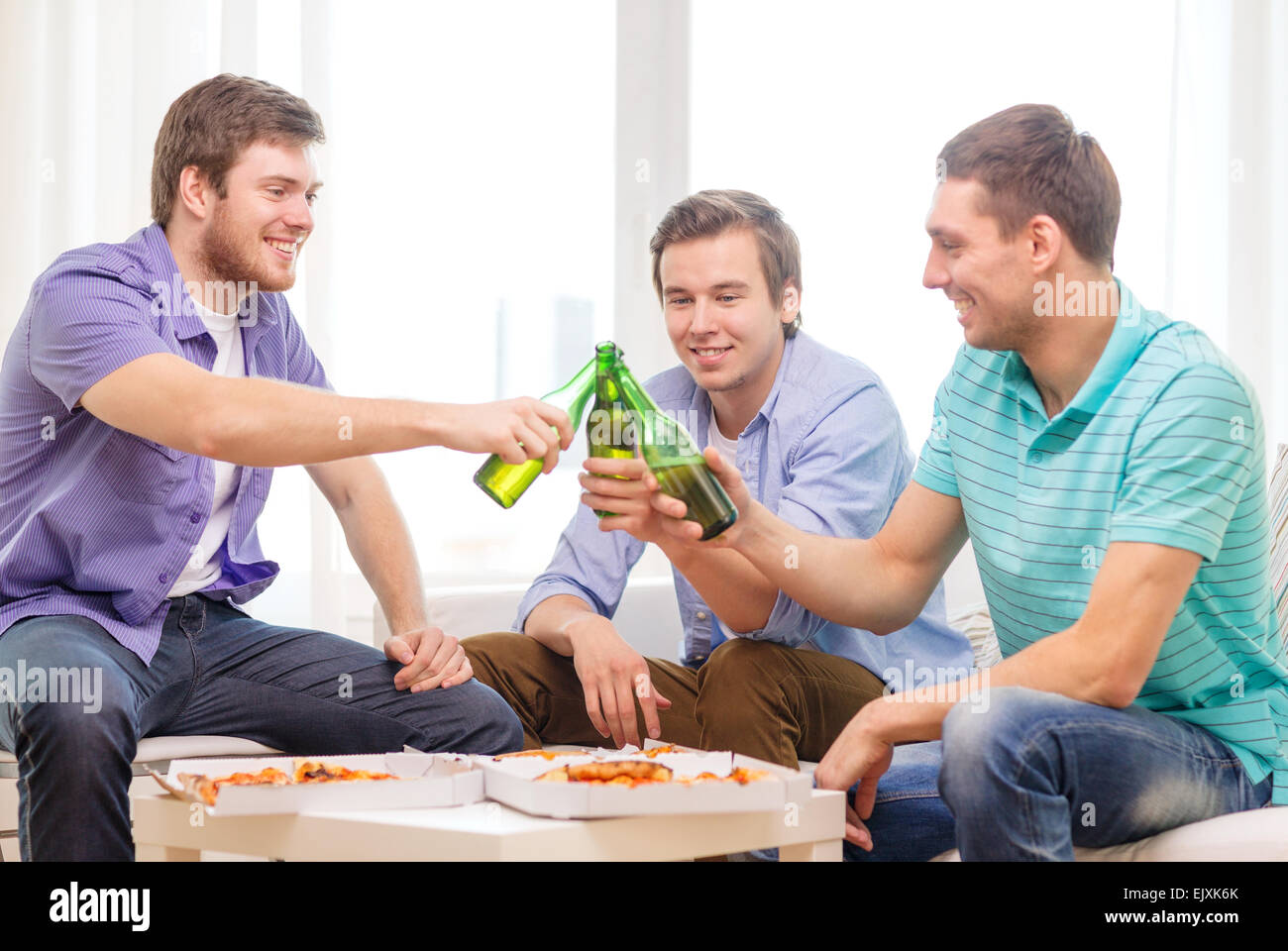 smiling friends with beer and pizza hanging out Stock Photo - Alamy