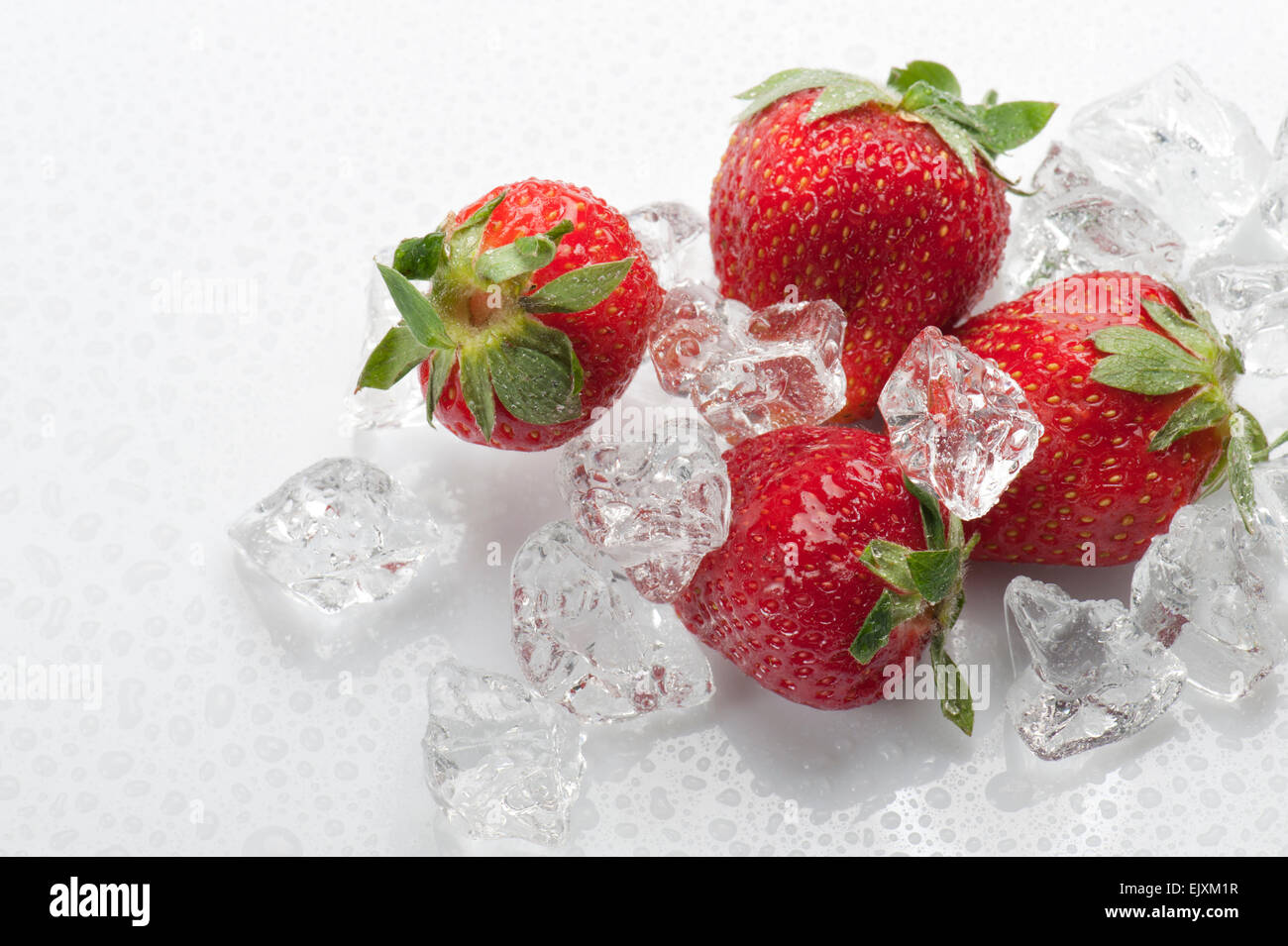 frozen strawberries with ice cubes, on white background Stock Photo - Alamy