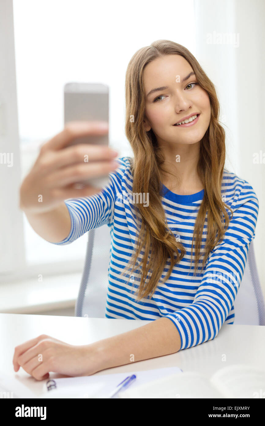 smiling student girl with smartphone and books Stock Photo - Alamy