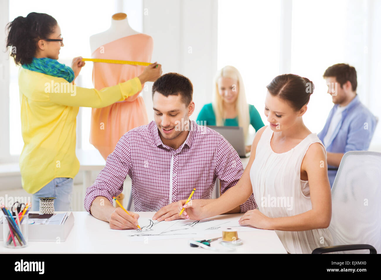 smiling fashion designers working in office Stock Photo - Alamy