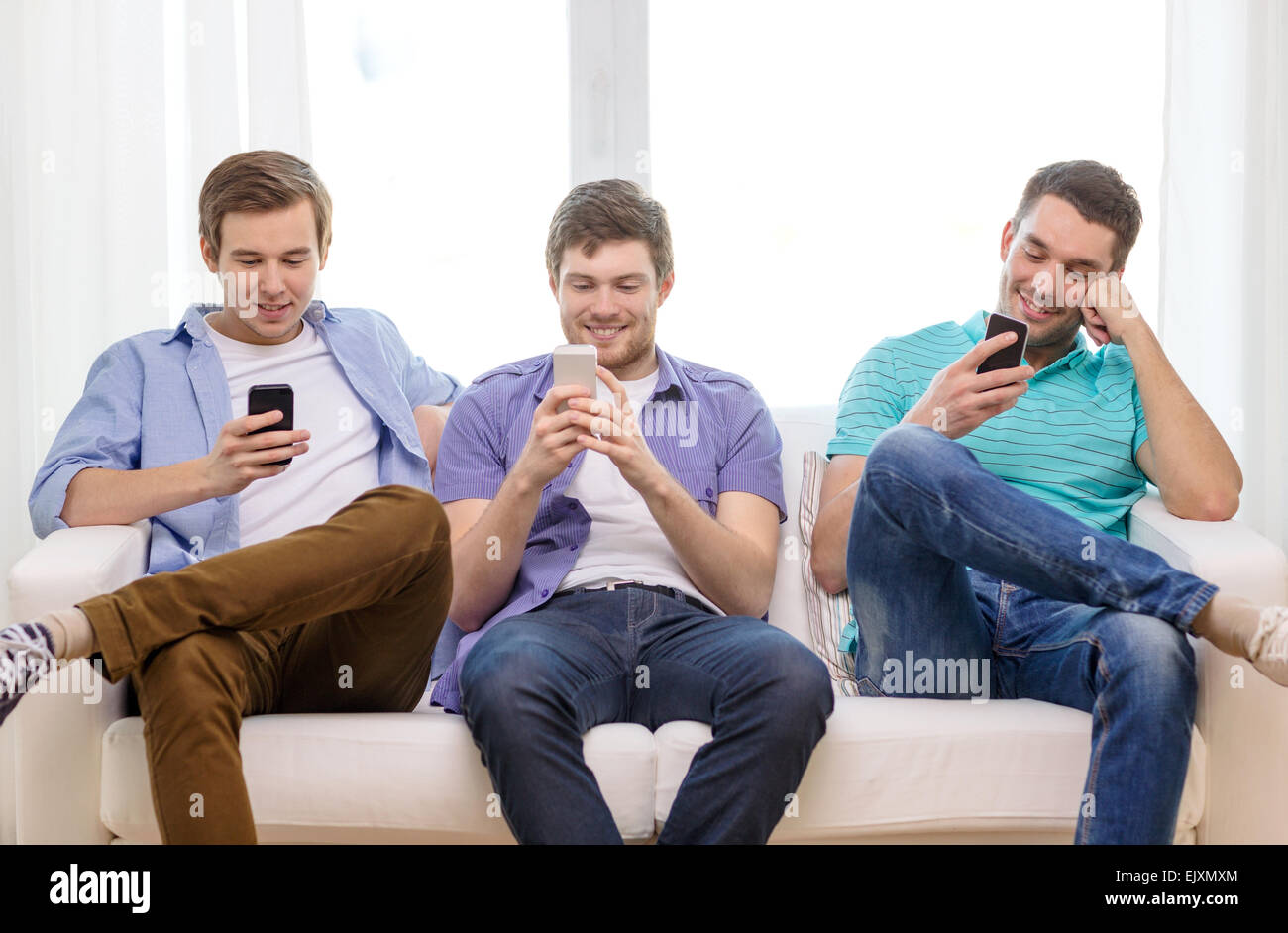 smiling friends with smartphones at home Stock Photo - Alamy