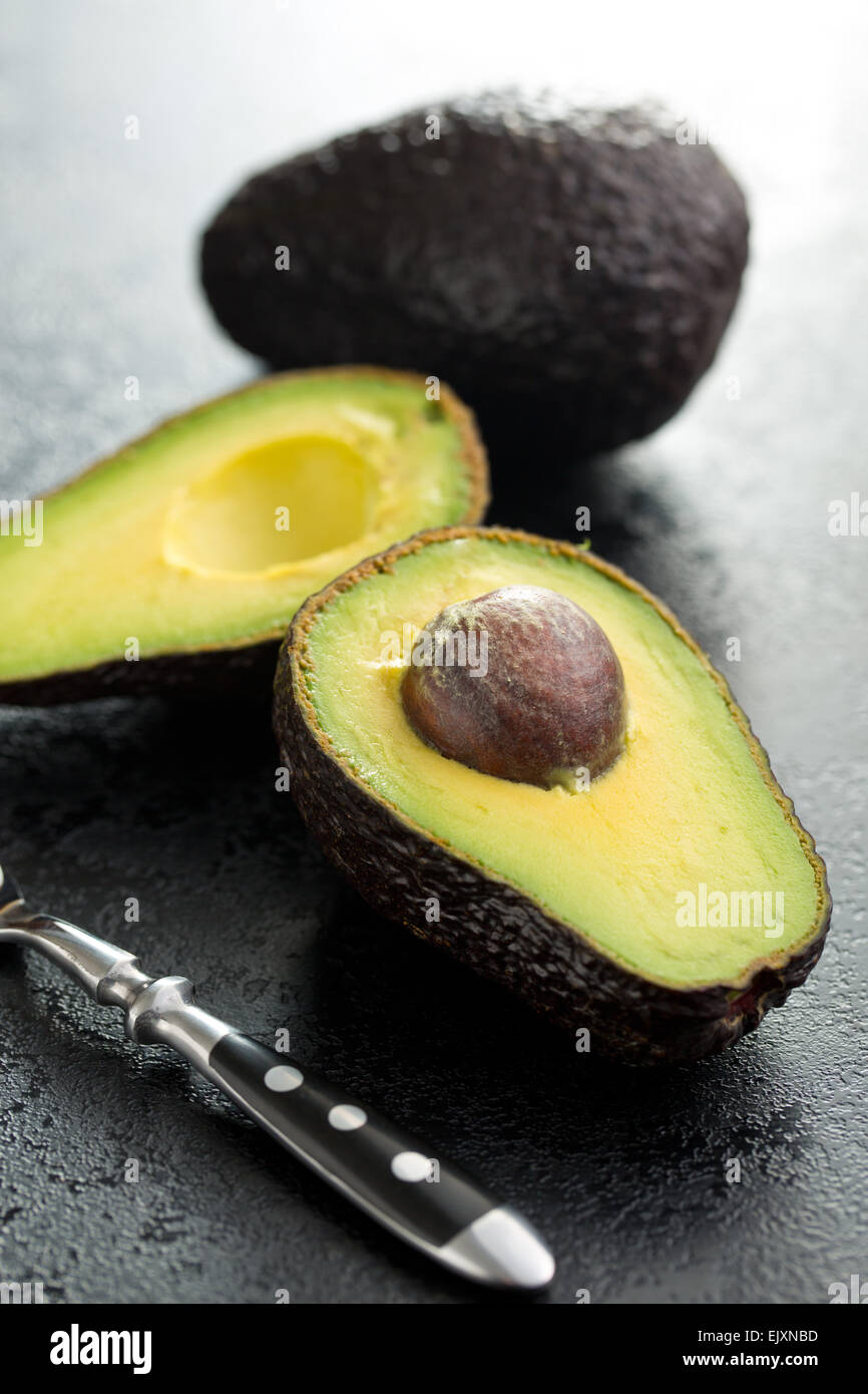 Half avocado on black background hi-res stock photography and images ...