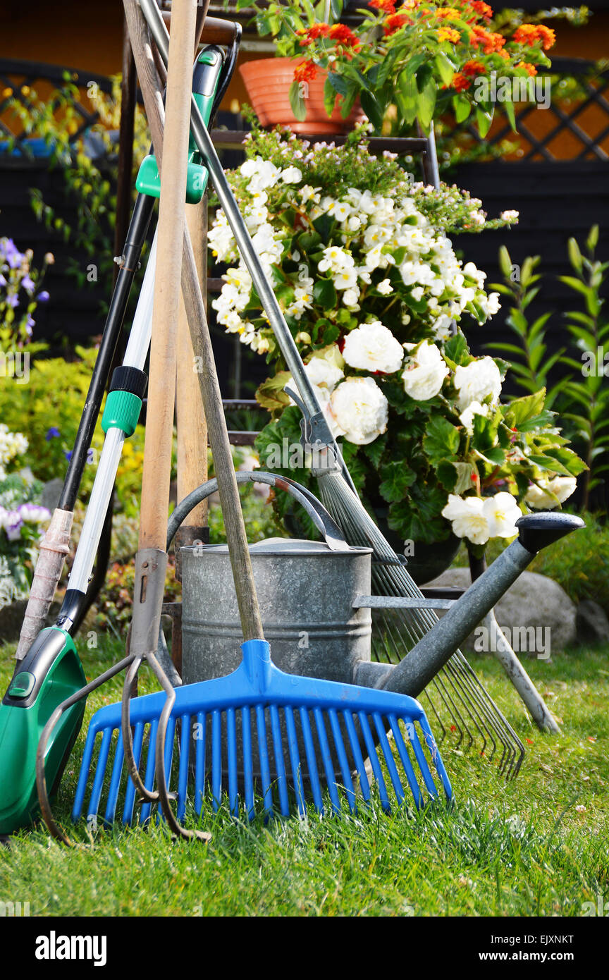 Watering can and tools in the garden Stock Photo - Alamy