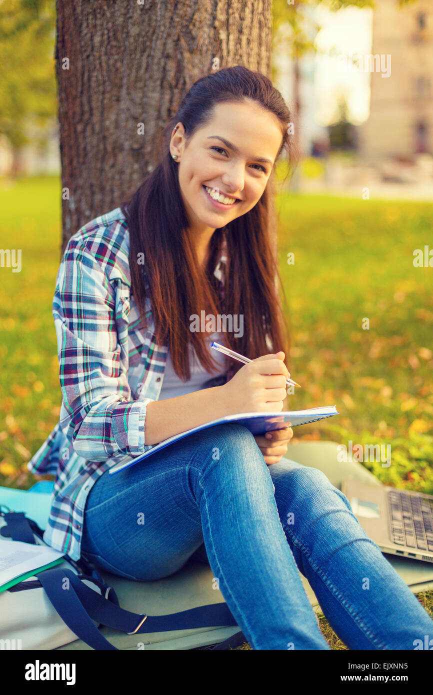 smiling teenager writing in notebook Stock Photo - Alamy