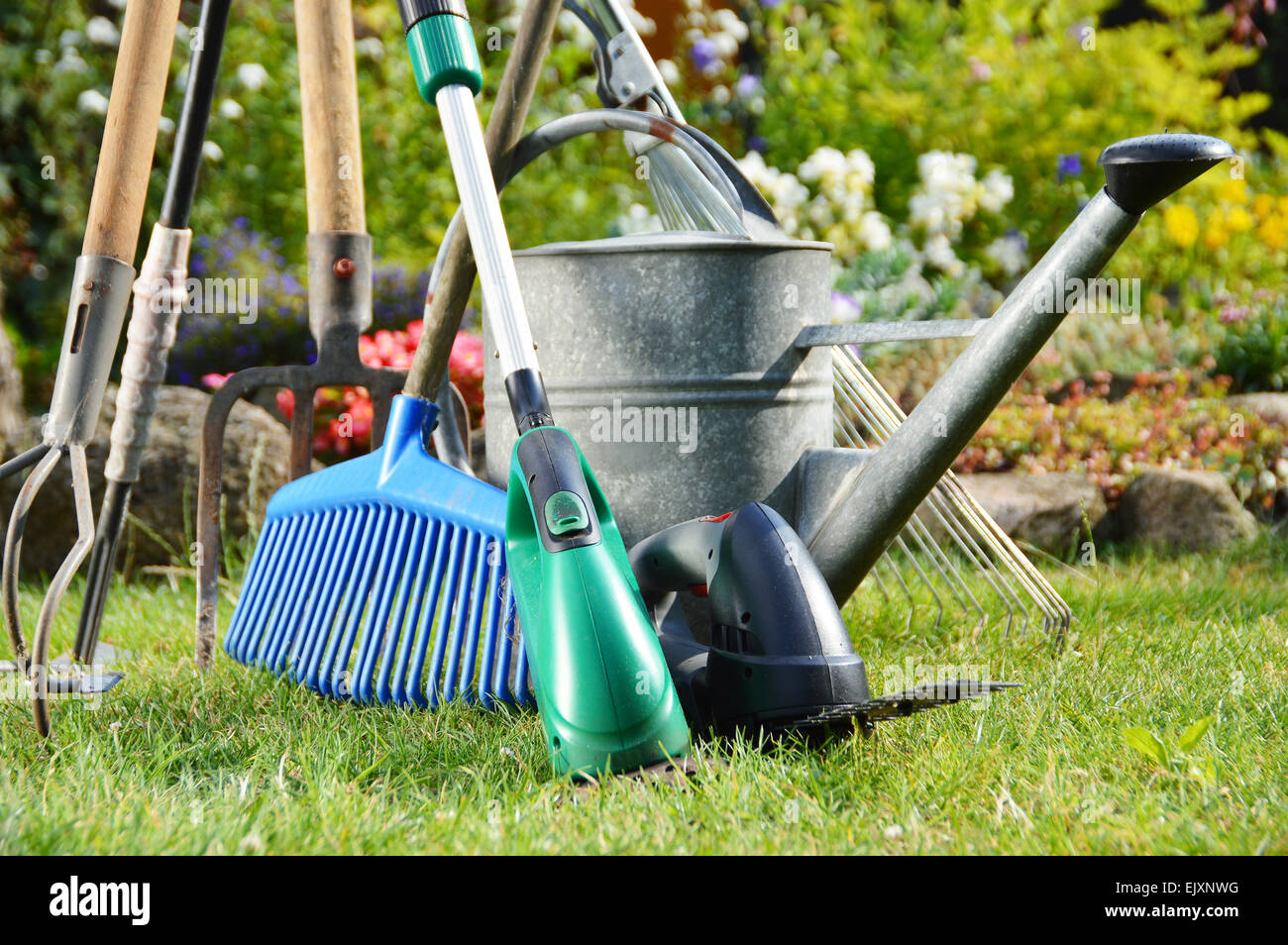 Watering can and tools in the garden Stock Photo - Alamy