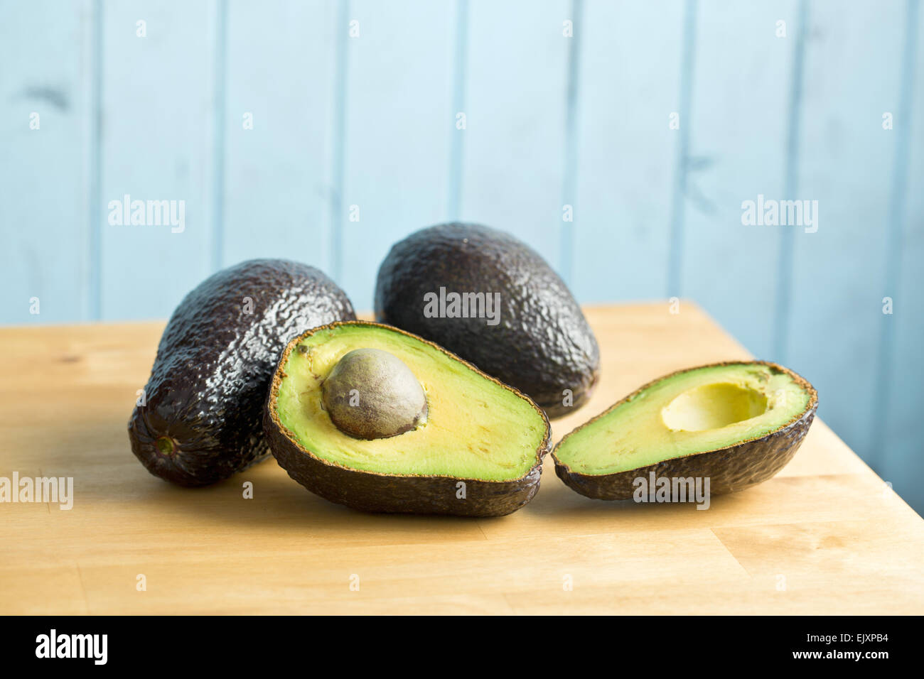 the halved avocado on kitchen table Stock Photo - Alamy