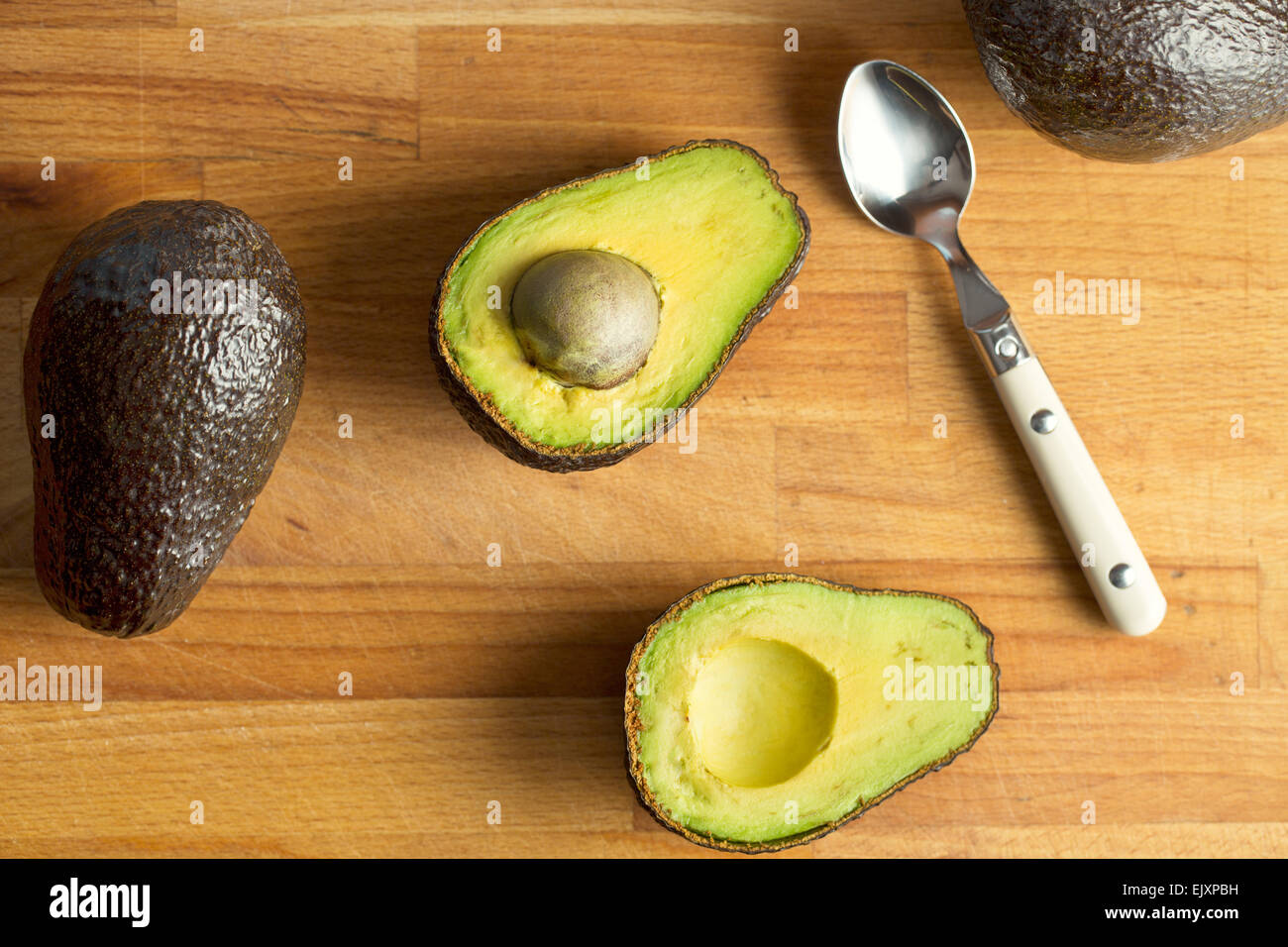 the halved avocado on kitchen table Stock Photo - Alamy