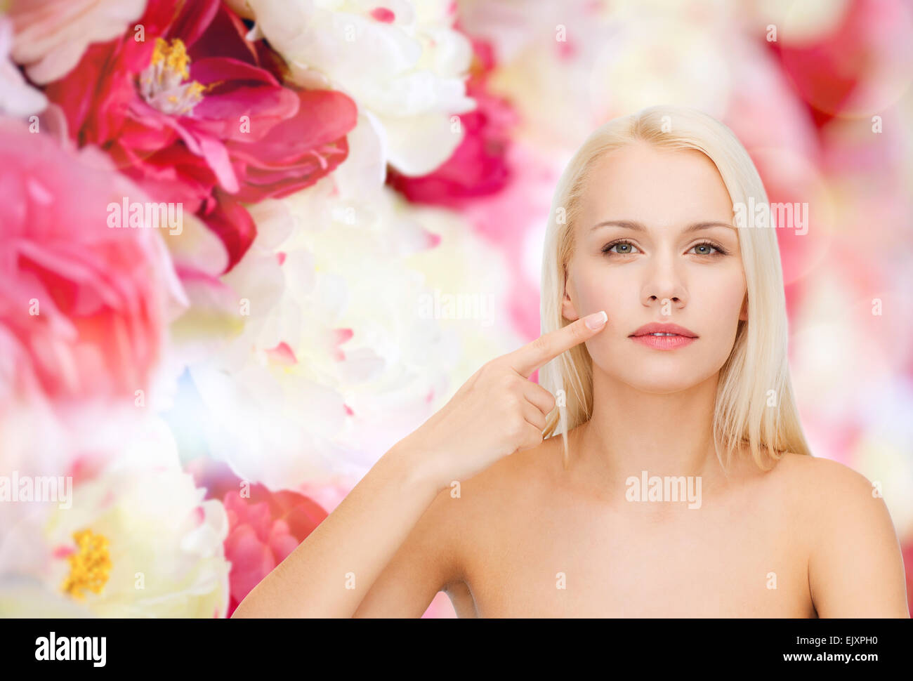 calm young woman pointing at her cheek Stock Photo - Alamy