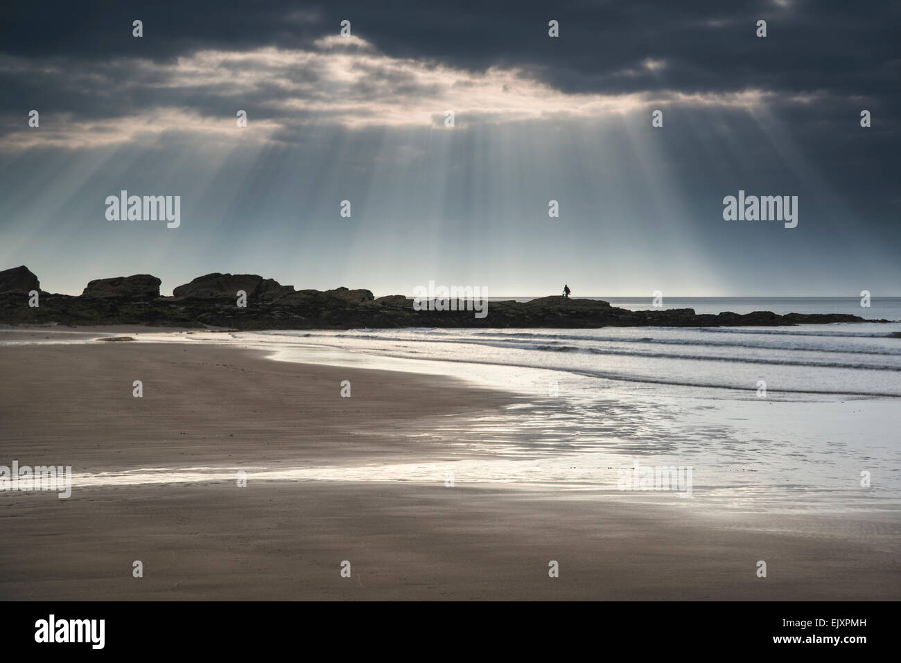 Stunning sun beams bursting from sky over empty yellow sand beach ...