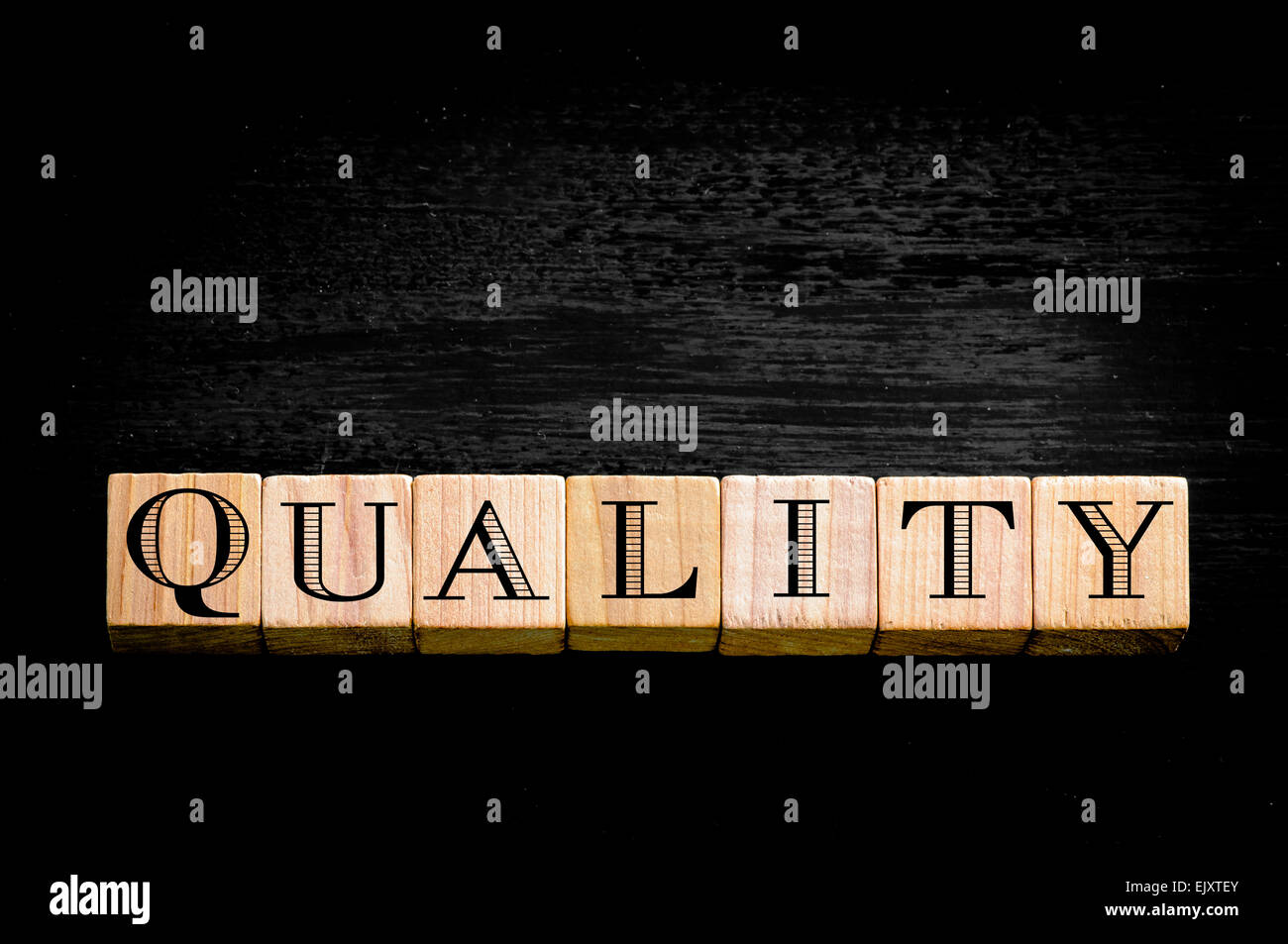 Word Quality.Wooden small cubes with letters isolated on black ...