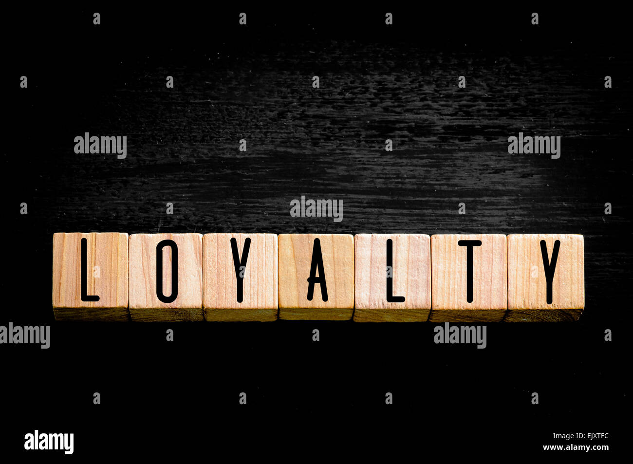 Word Loyalty.Wooden small cubes with letters isolated on black ...