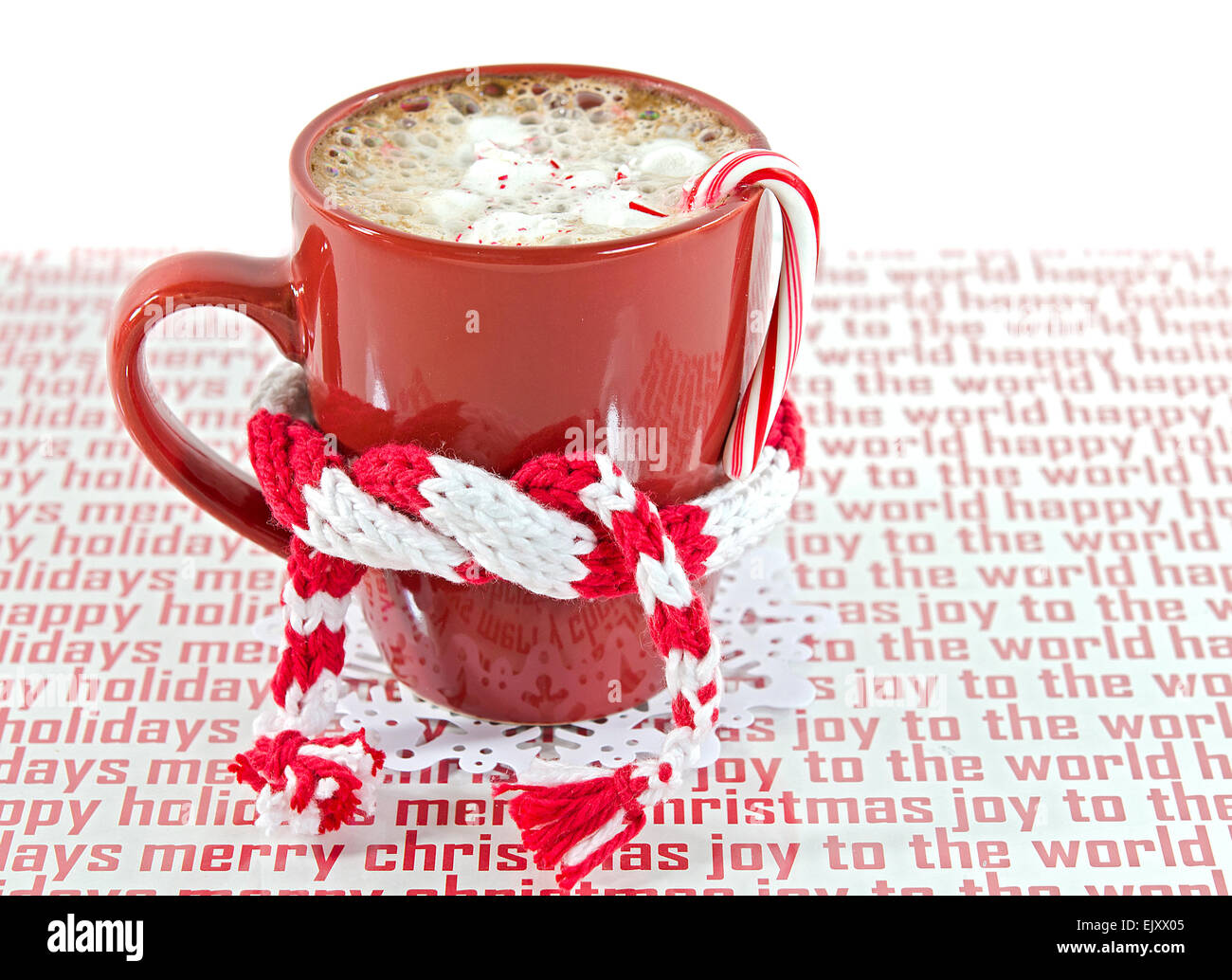 Hot chocolate drink with candy cane in a red mug with knitted scarf and ...