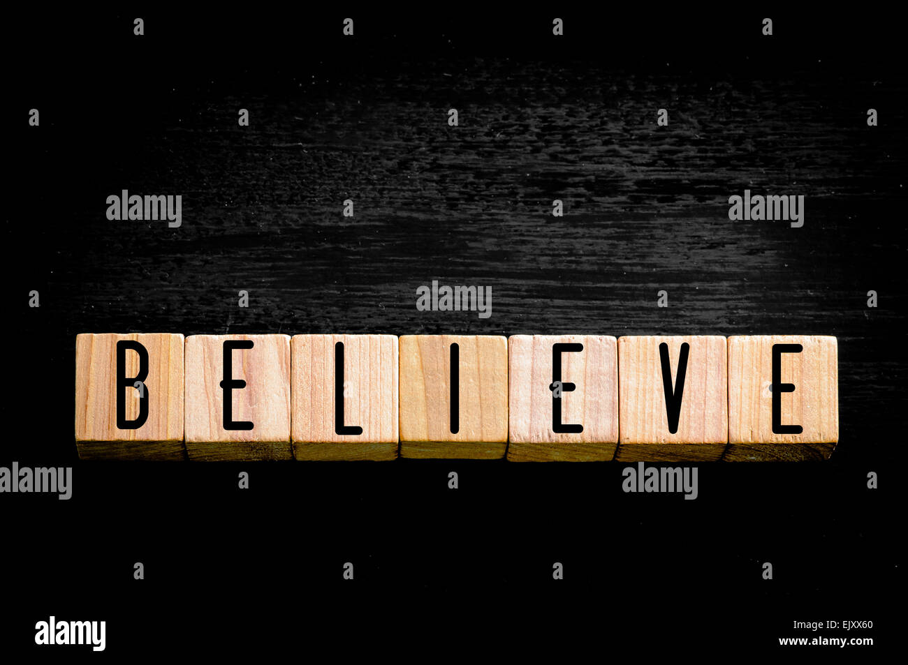 Word Believe. Wooden small cubes with letters isolated on black ...