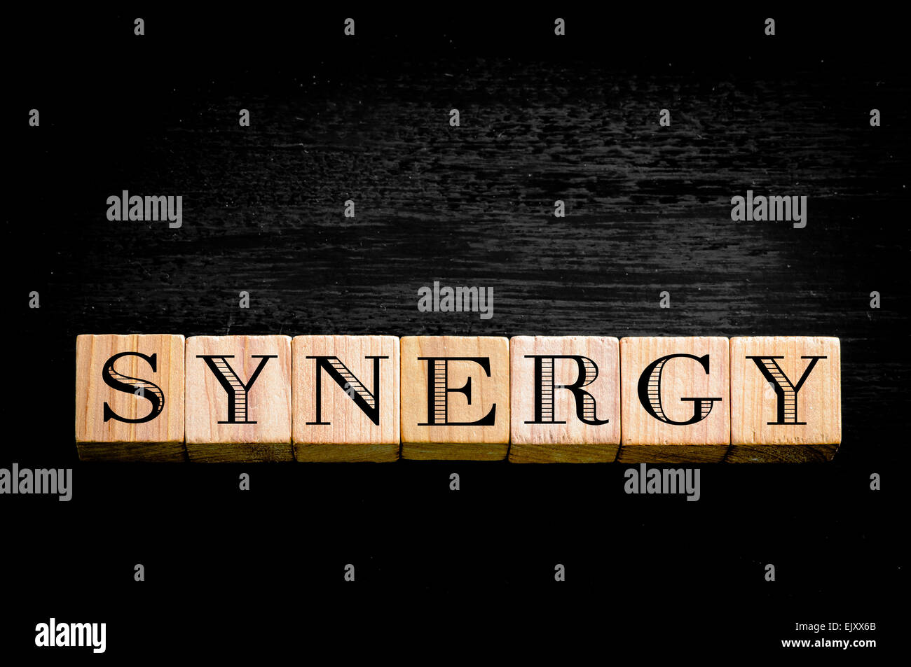 Word Synergy. Wooden small cubes with letters isolated on black ...