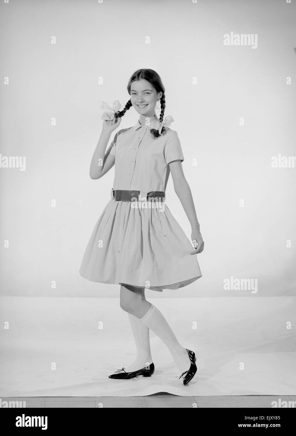 Model Jennifer Goddard. Brown-haired girl in checkered dress with pig ...