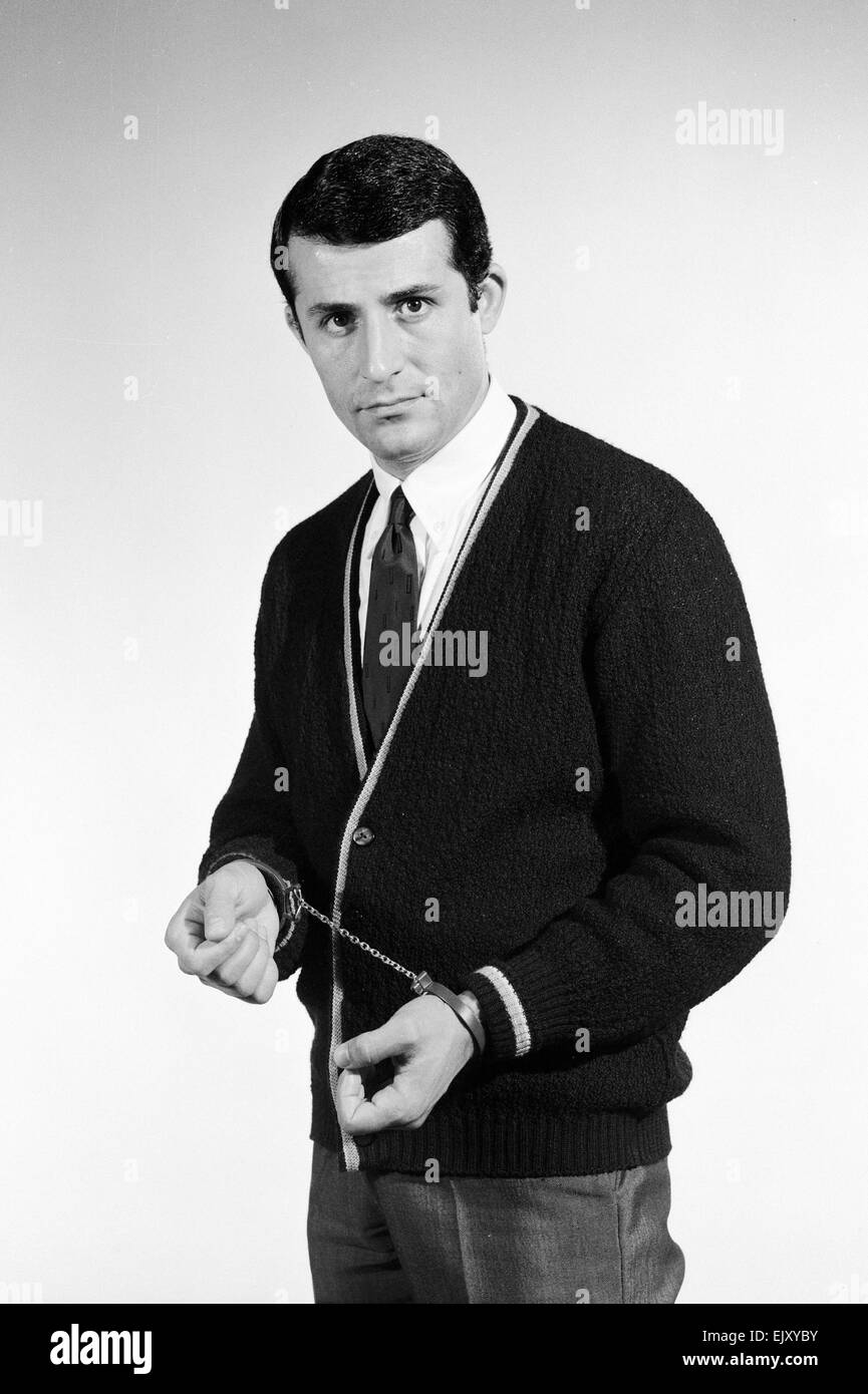 Handcuffs feature. Model Henry Fern in cardigan wearing handcuffs Stock ...