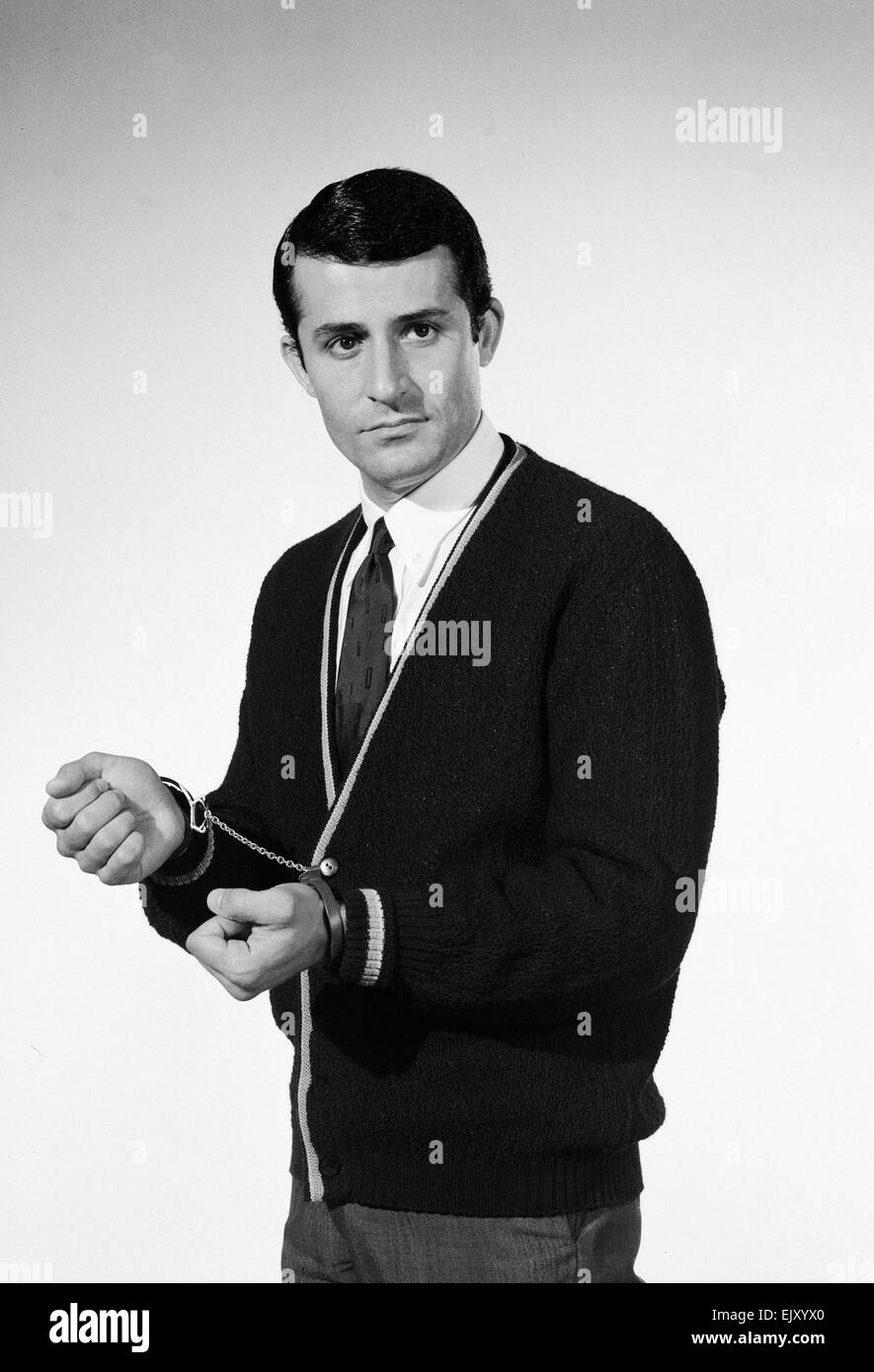 Handcuffs feature. Model Henry Fern in cardigan wearing handcuffs Stock ...