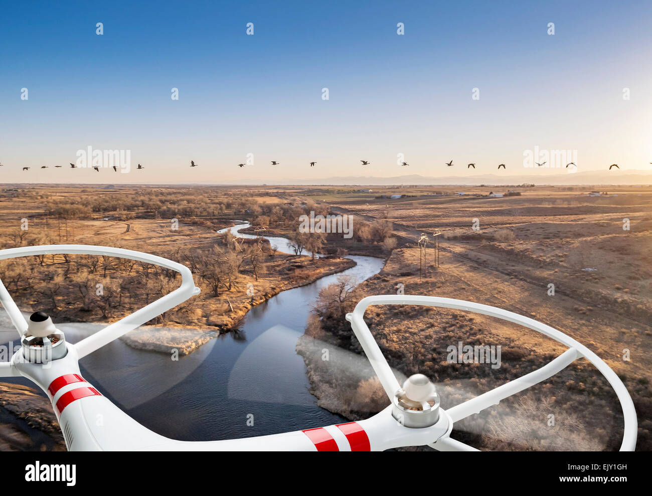 A small quadcopter drone flying over river landscape with Canadian ...