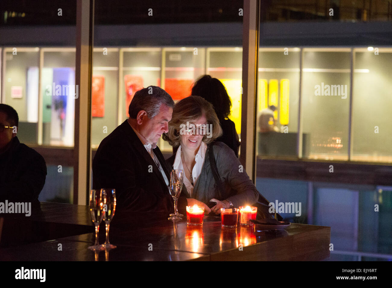 Party, couple watching smartphone at bar Stock Photo - Alamy
