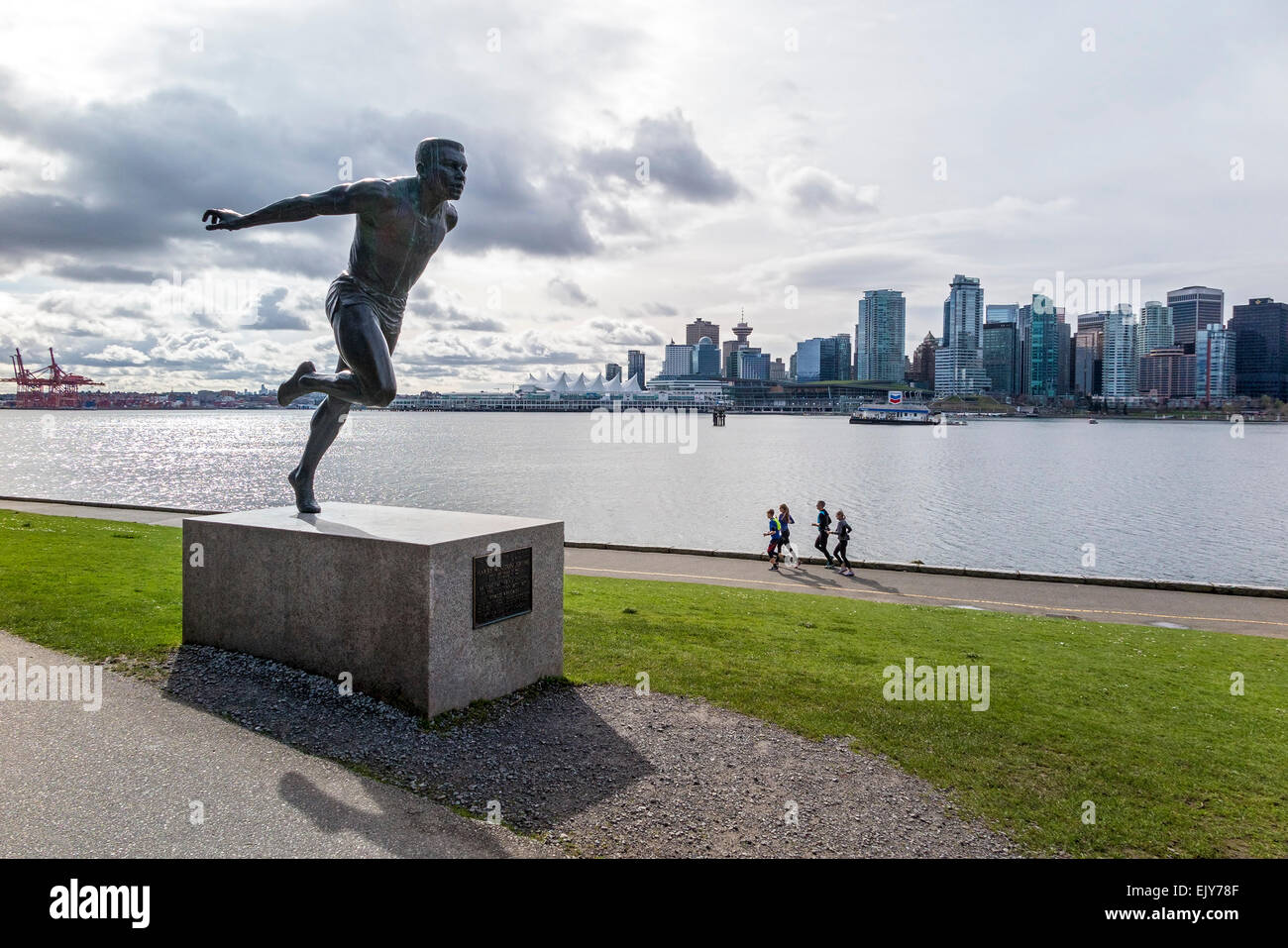 People running and jogging alone the seawall of Stanley Park, Vancouver ...