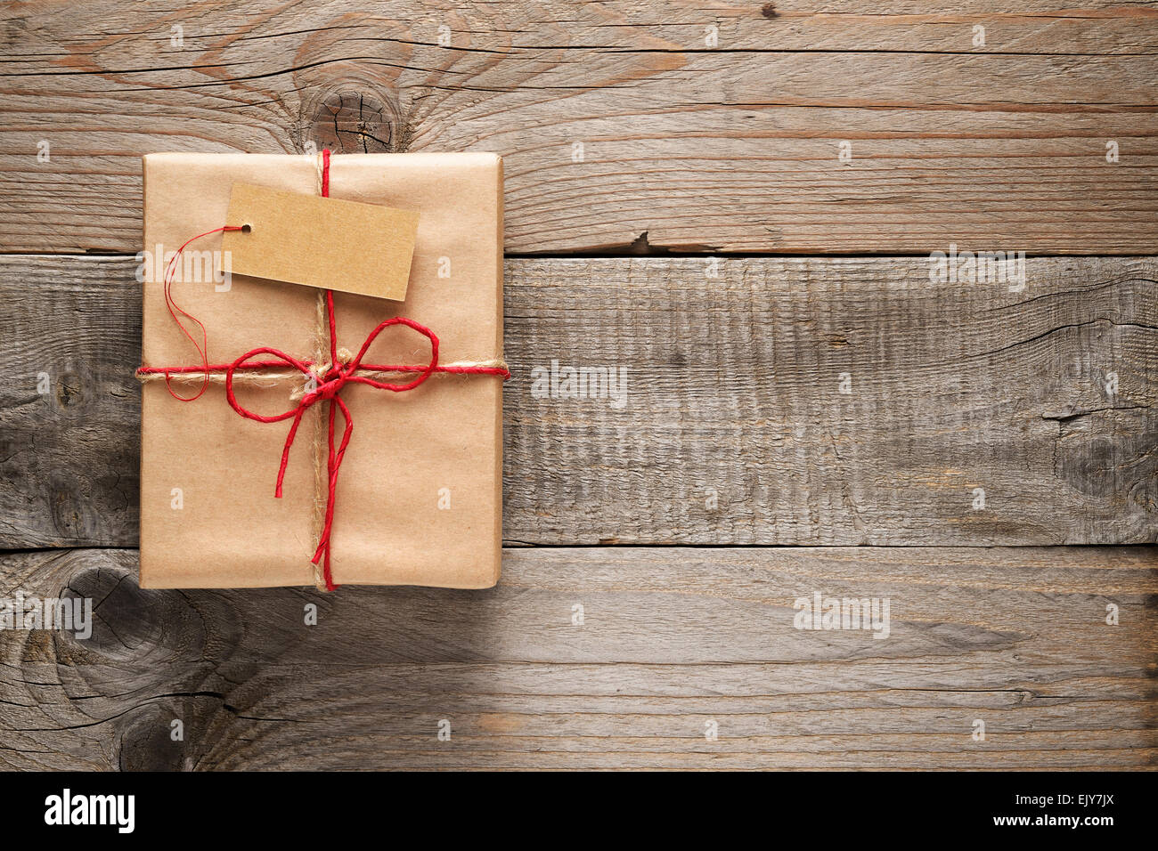 Gift box with tag on wooden background Stock Photo - Alamy