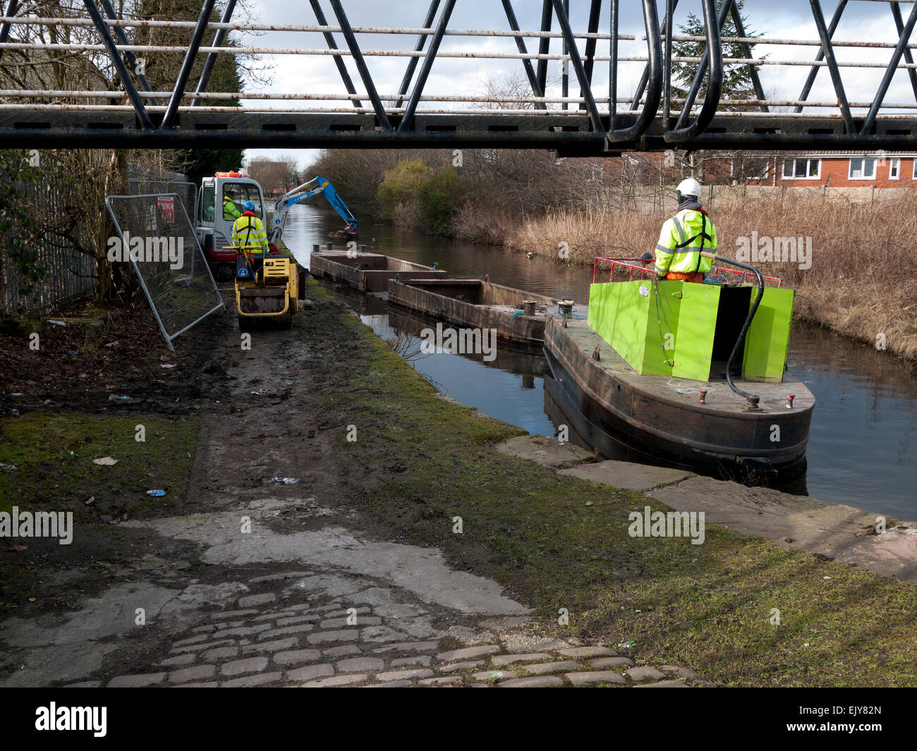 Workman resurfacing the towpath on the Ashton Canal, Droylsden ...