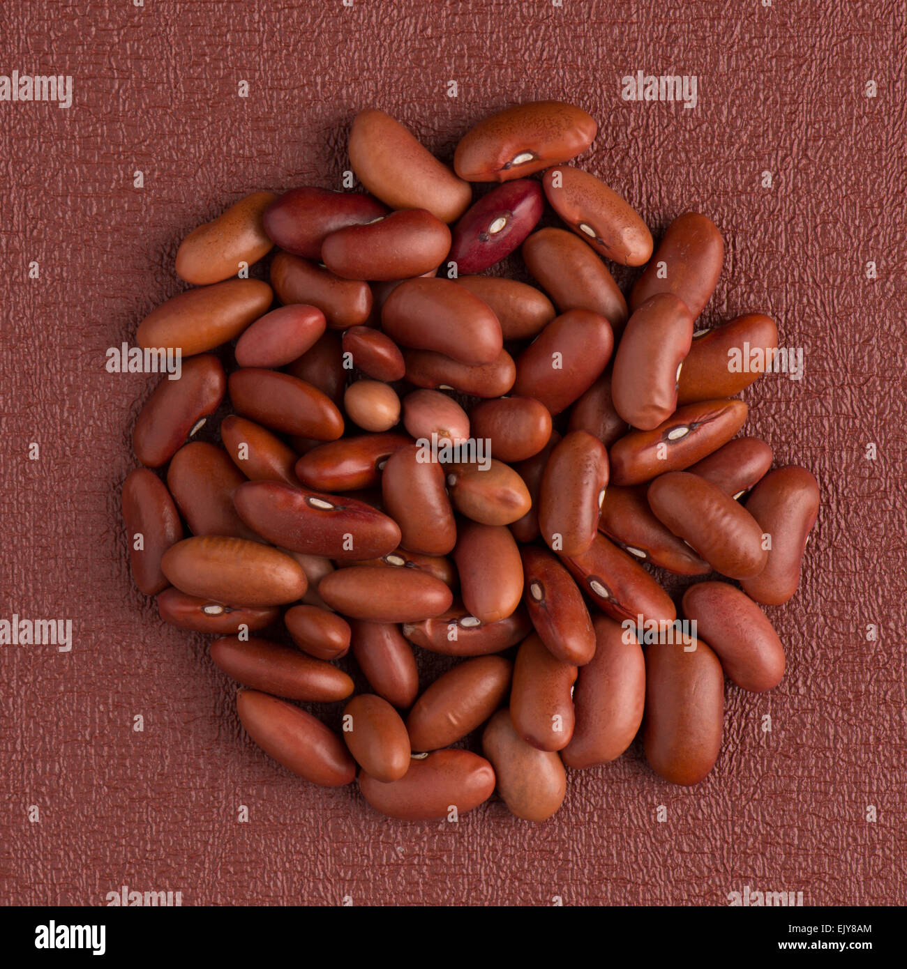 Circle of red beans on red vinyl background Stock Photo - Alamy